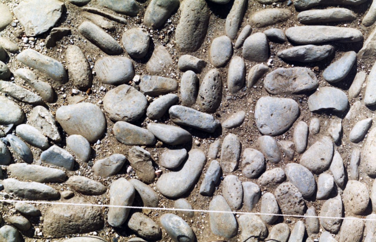 Piso de calhau rolado médio encontrado sob lajeado de cantaria nas ...